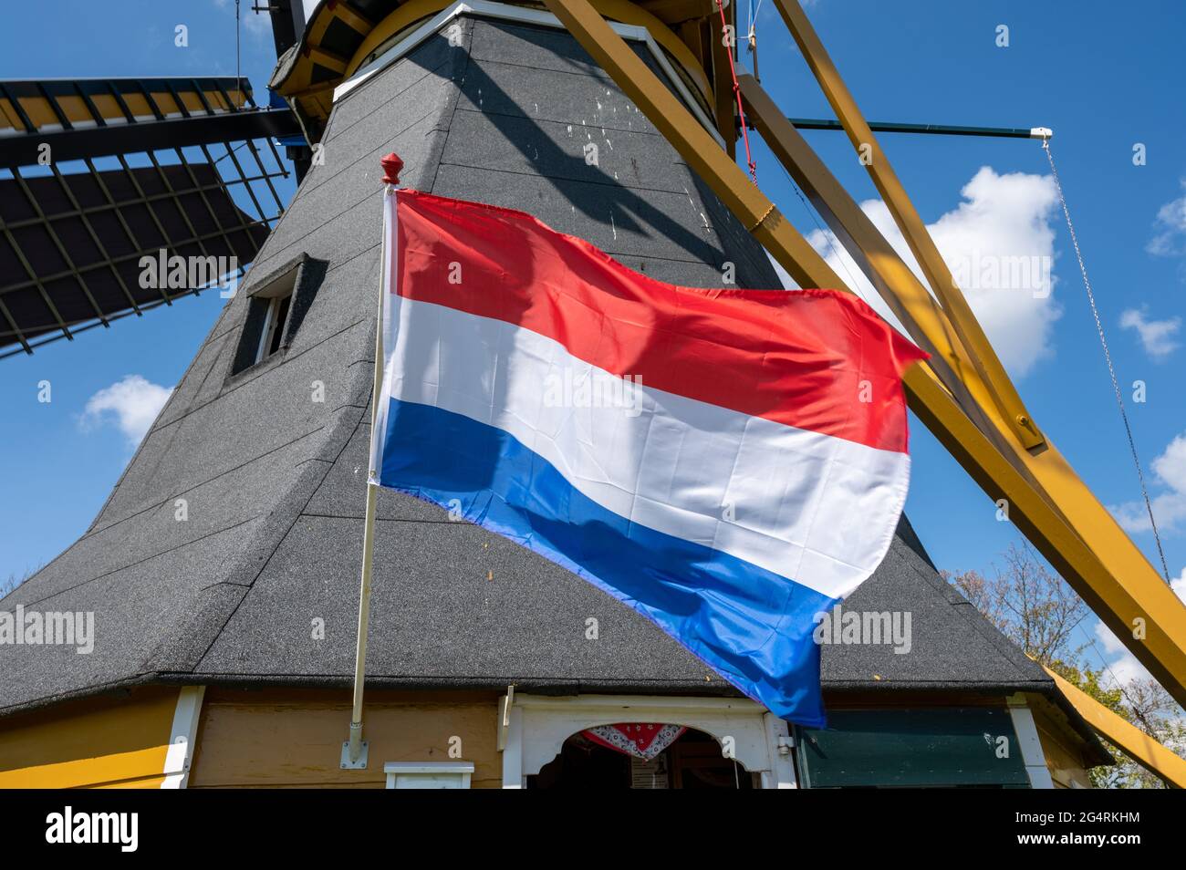 Dutch flag and old traditional windmill used for grain grinding on ...