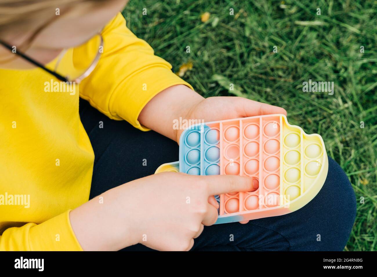 Top view of child playing with colorful poppit sensory game together ...