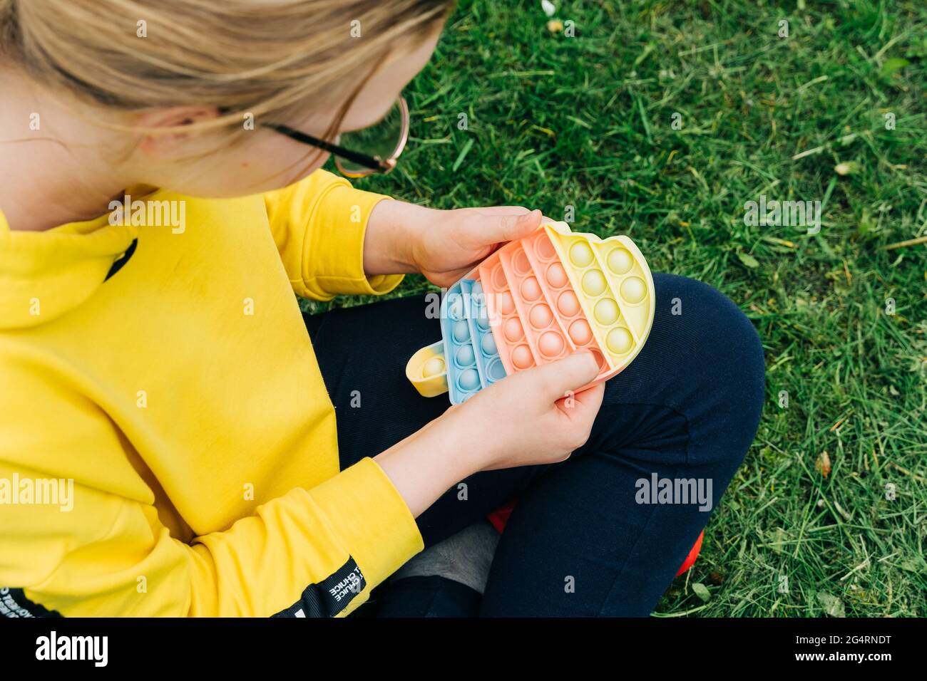 girl teen playing colorful poppit sensory game. Close up of kid hands ...
