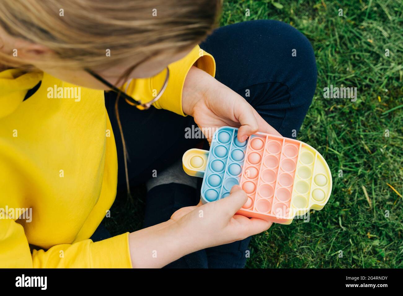 Top view of child playing with colorful poppit sensory game together ...