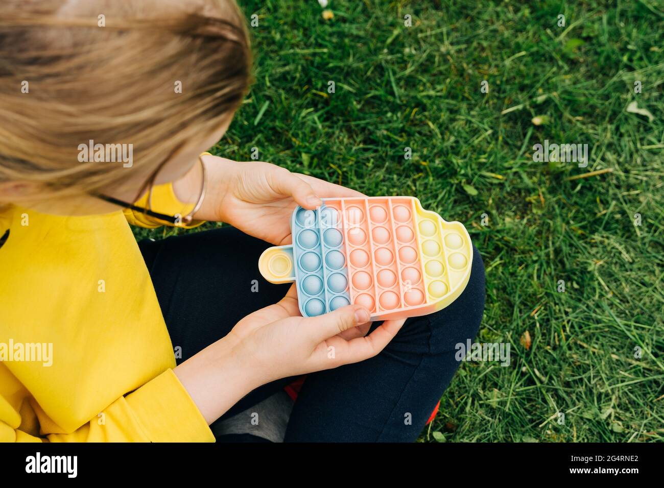 Top view of child playing with colorful poppit sensory game together ...