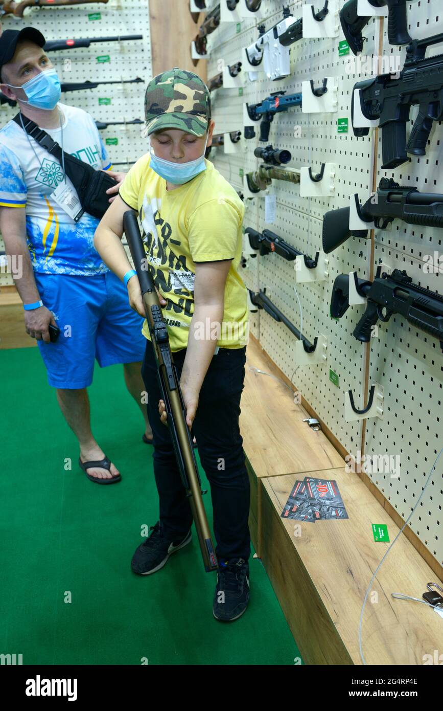Little boy trying the rifle in a gun shop. Arms and Safety Exhibition ...