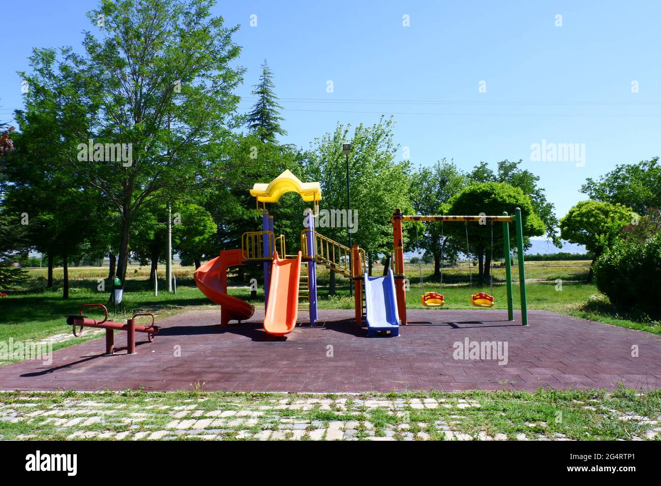 Kids' Playground outdoor within trees in a sunny day Stock Photo - Alamy