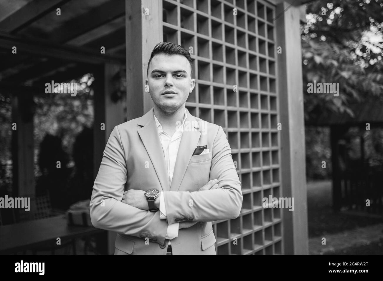 Grayscale shot of young handsome Caucasian male wearing a nice elegant ...