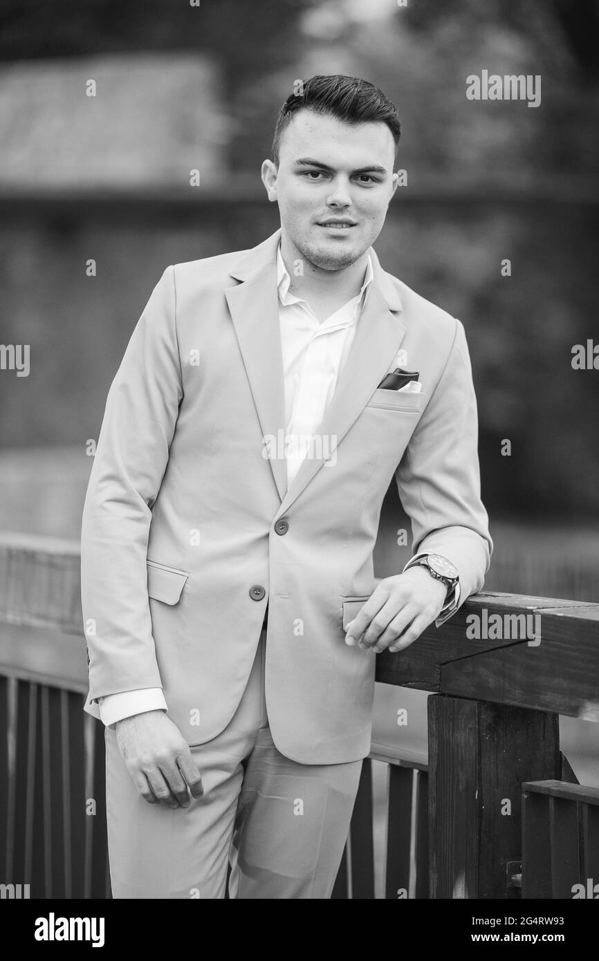 Vertical grayscale shot of a young handsome Caucasian male wearing a ...