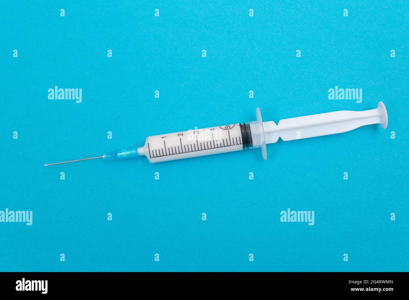 A Syringe with White Liquid Inside on Blue Table. Disposable Plastic ...