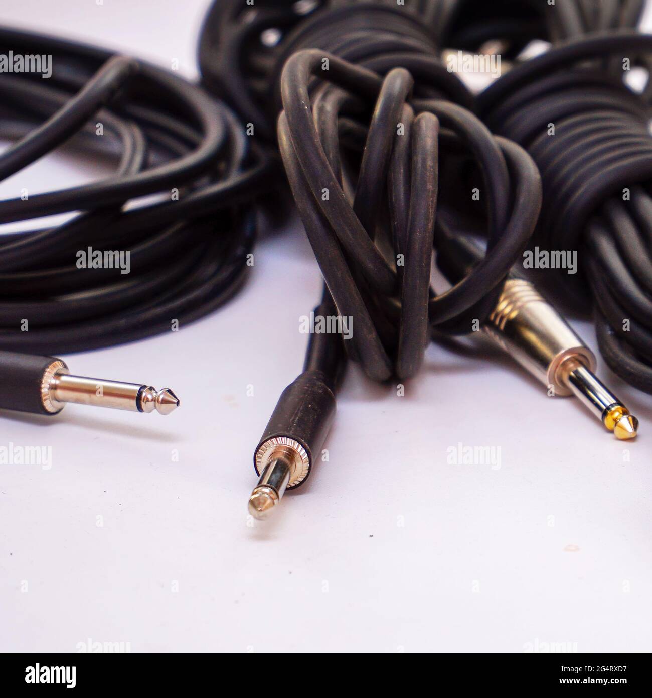Audio cables for musical instruments and microphones on a white ...
