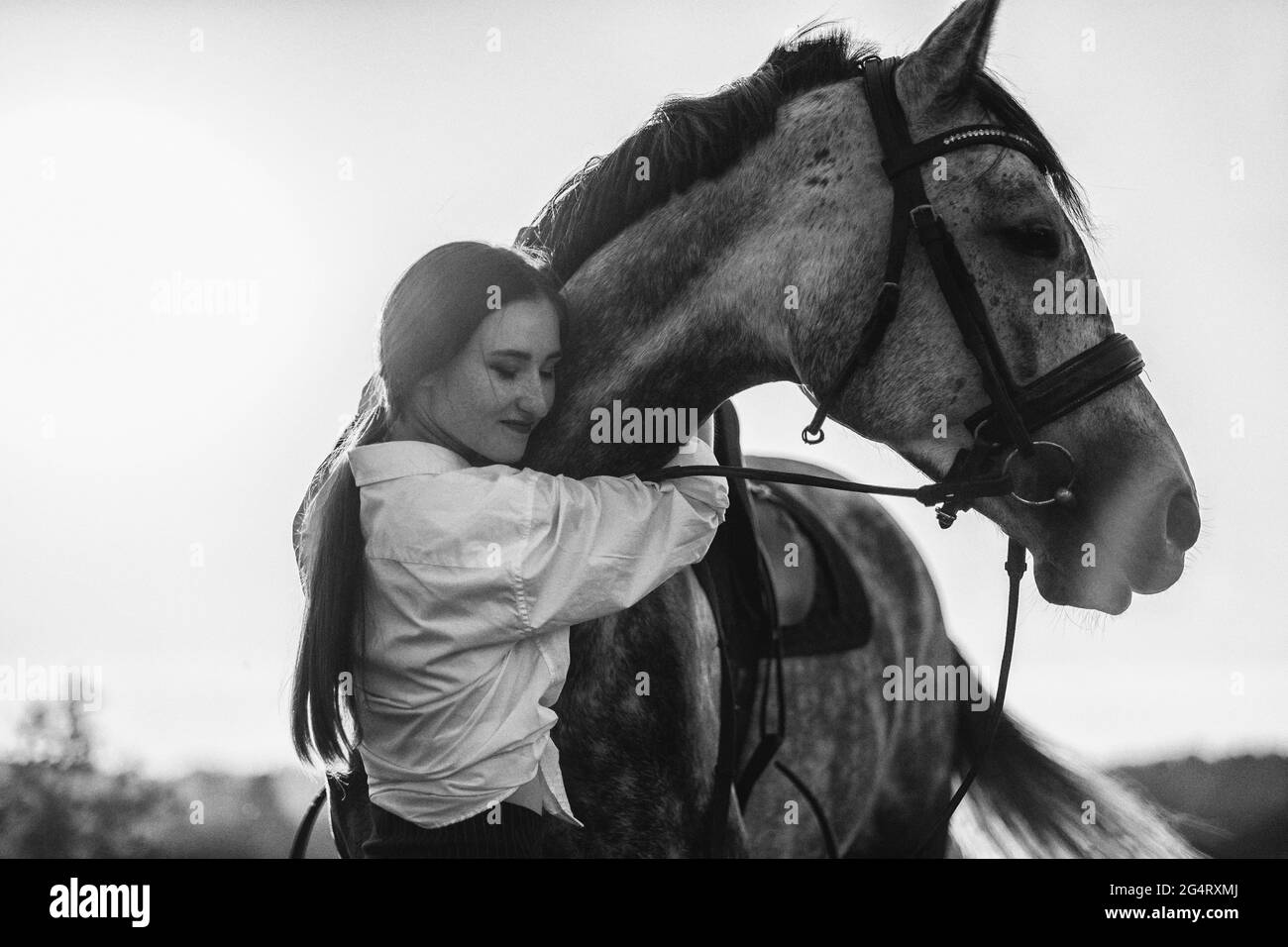 Young beautiful woman taking care of her horse hugging it Stock Photo ...