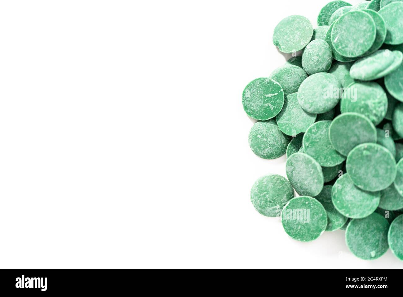 Green round chocolate chips for melting chocolate shapes on a white ...