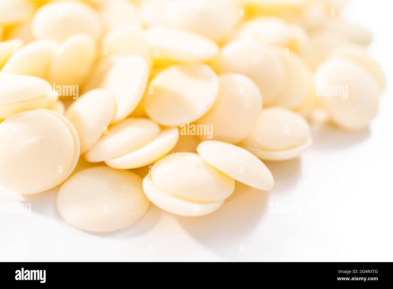 White round chocolate chips for melting chocolate shapes on a white ...