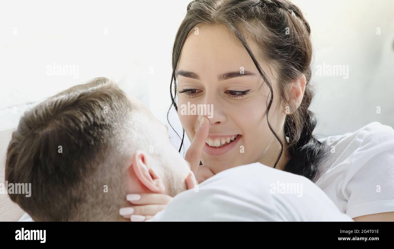 boyfriend touching nose of happy brunette woman with braids Stock Photo ...