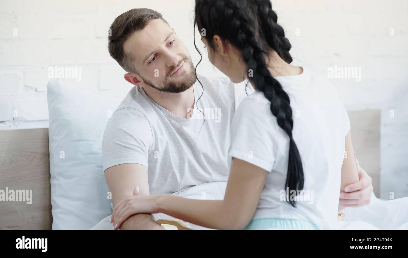 caring man hugging girlfriend with braids in bedroom Stock Photo - Alamy
