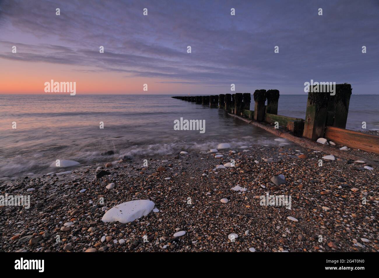 Groynes at the north beach in Bridlington at dawn, with motion blur of ...