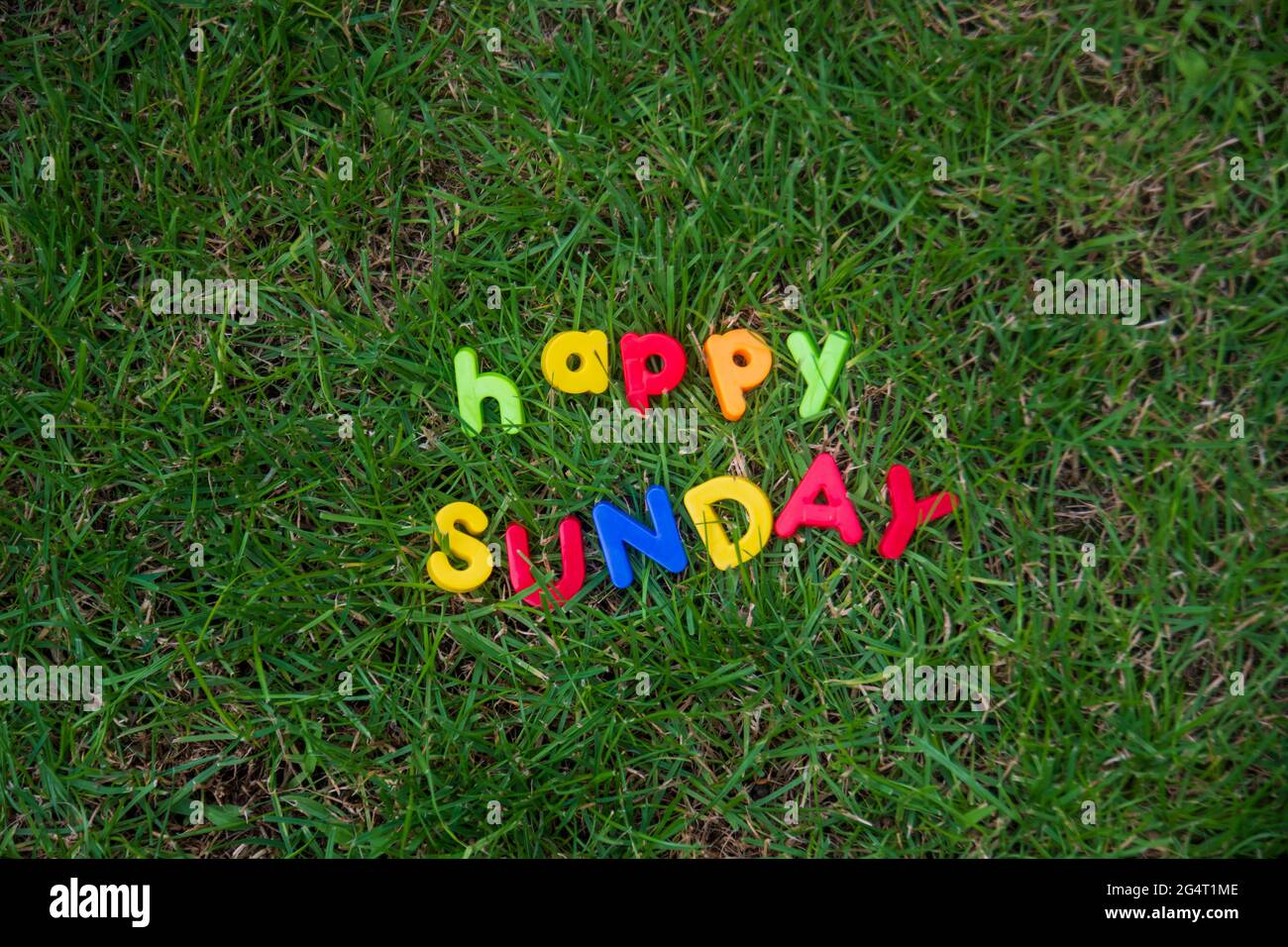happy sunday lettering written with toy letters on the grass in the ...