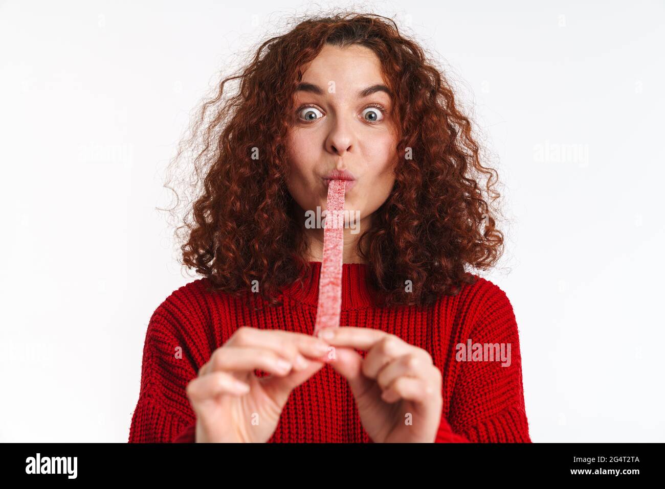 Shocked ginger young woman making fun with gummy isolated over white ...