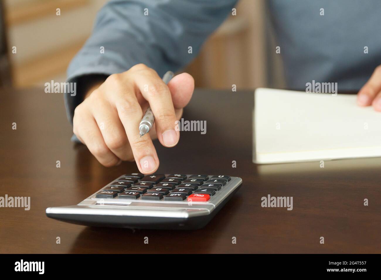 Close up hand man use calculator to calculate something Stock Photo - Alamy