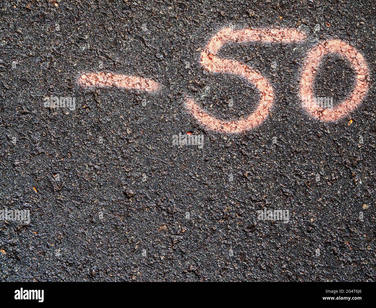 Top view of number minus 50 written on asphalt in pink color Stock ...