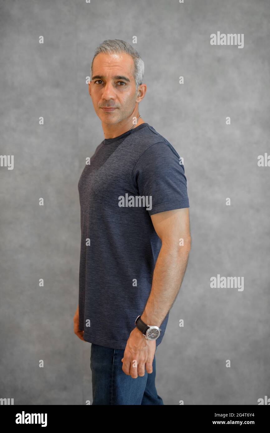 Side view portrait of handsome man standing against gray wall Stock ...
