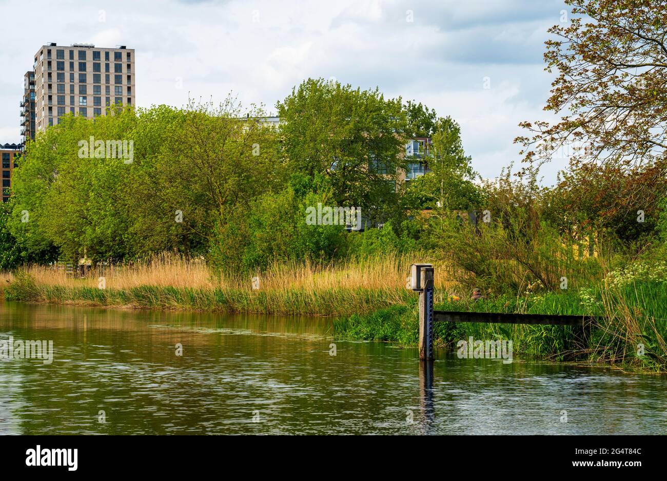 Riverside with apartment building and water level meter Stock Photo - Alamy