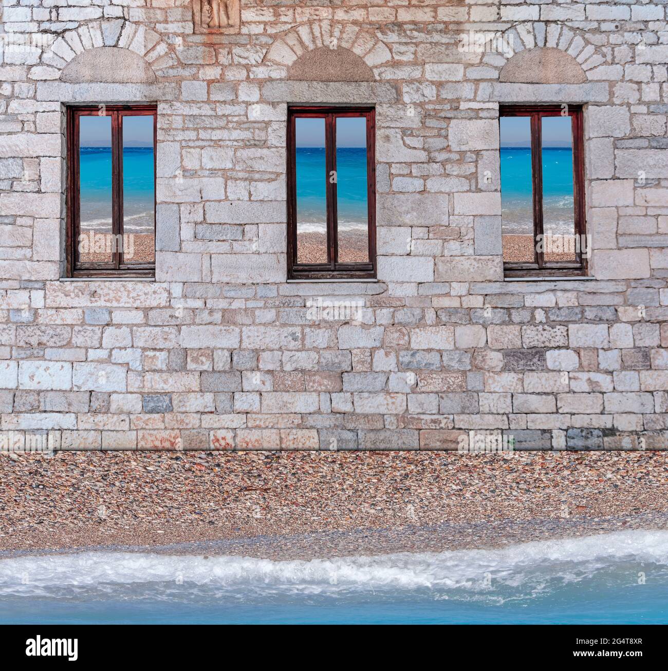Old stone house with blue sea reflection on windows and sea in ...