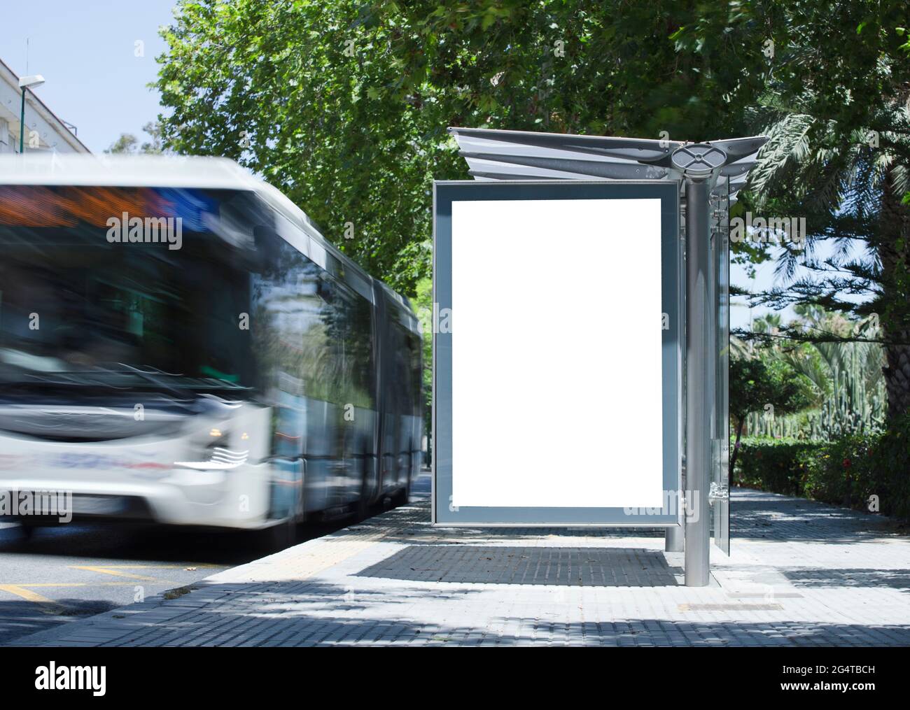 White blank vertical billboard at the bus stop on the city street. In ...