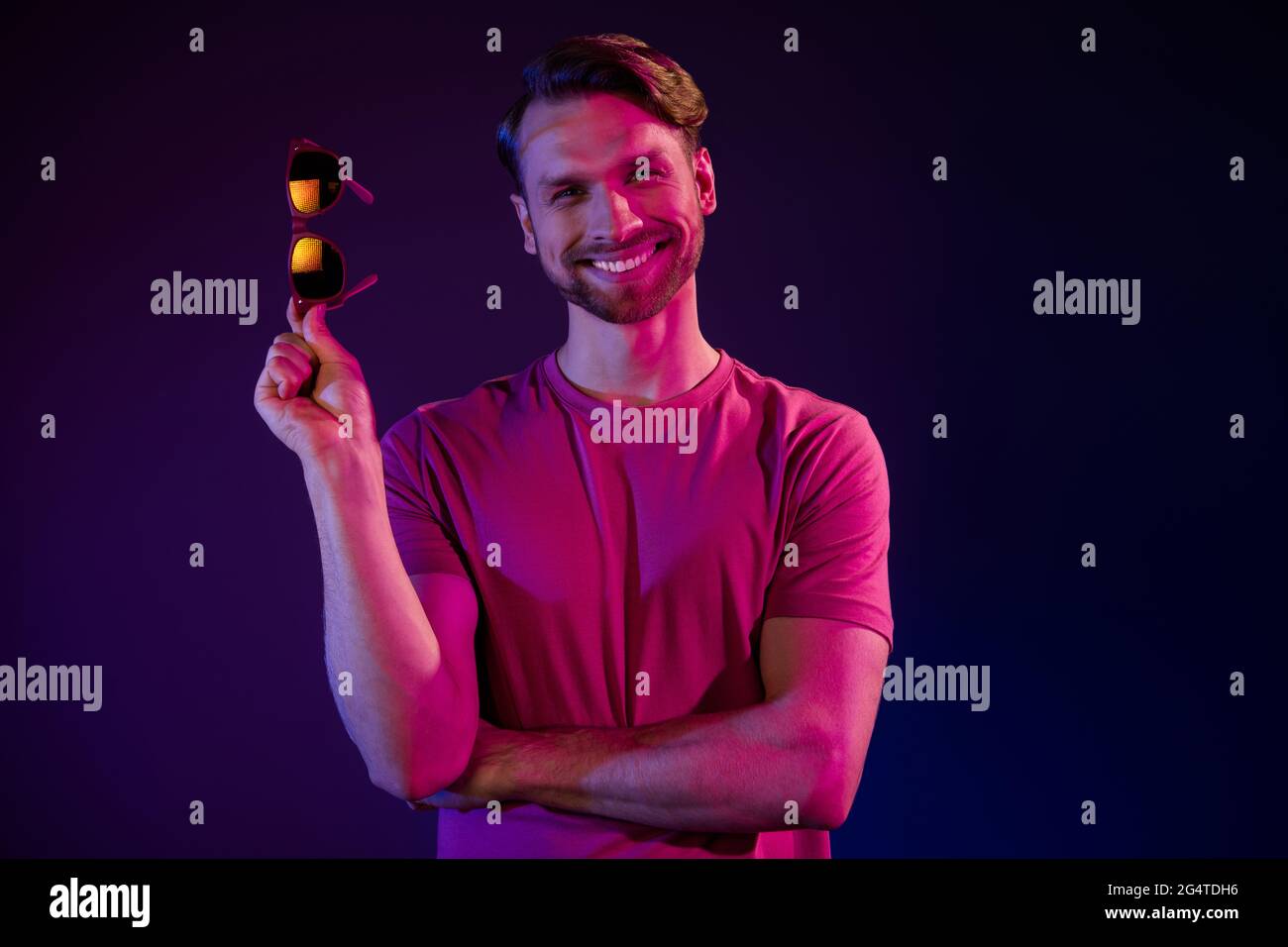 Portrait of attractive cheerful dandy guy holding in hand specs posing ...