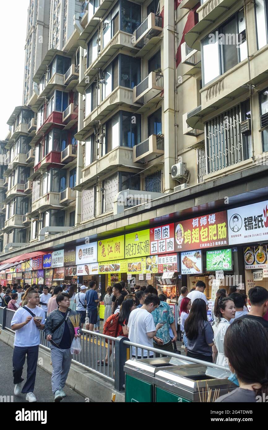 CHENGDU, CHINA - JUNE 22, 2021 - Citizens buy food at a street stall in ...
