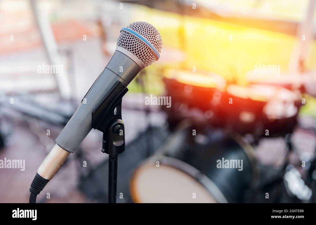 Electronic microphone on background of musical instruments drums with ...