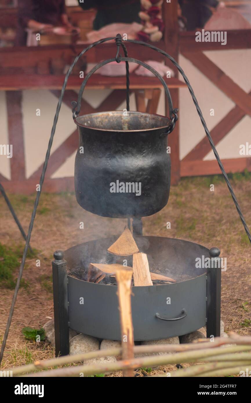 Preparing food in hanging pot over open fire - camping concept Stock ...