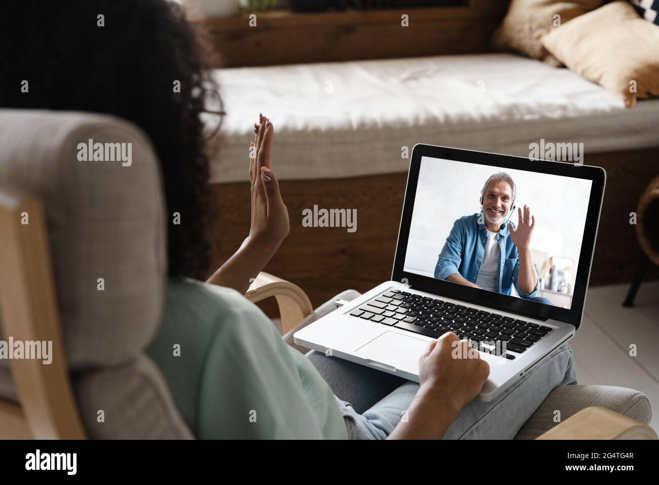 Laptop screen over woman shoulder view, communication group videocall ...