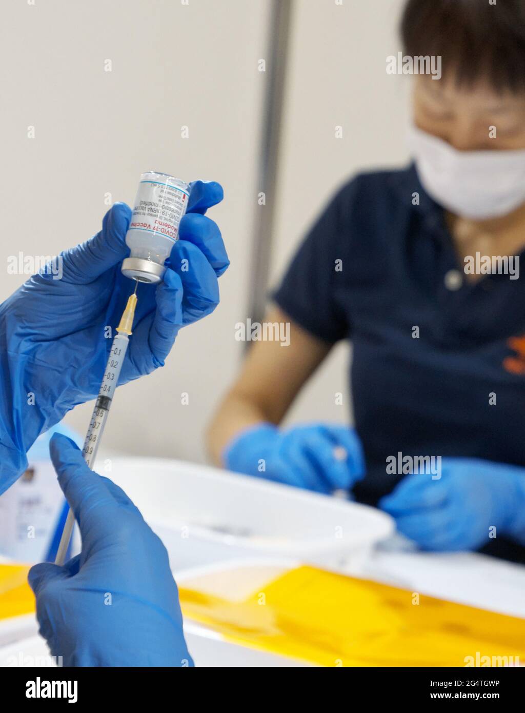 Naha, Japan. 23rd June, 2021. A medical worker fills a syringe with a ...