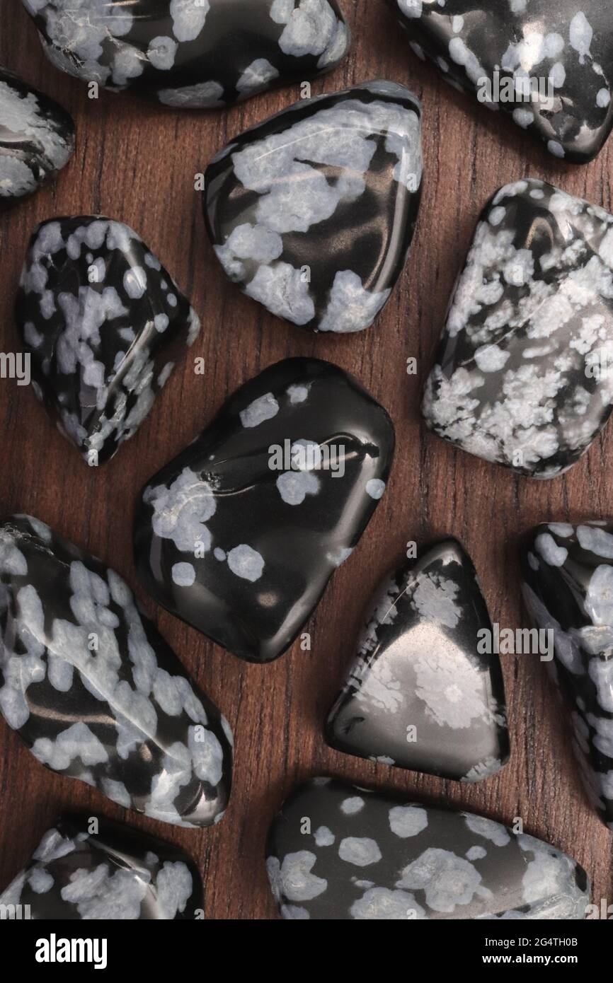 Snowflake rare jewel on half brown varnished wood texture. Pile mineral ...