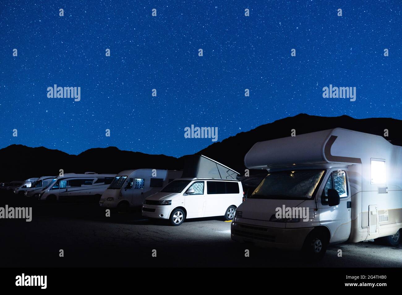 Campers parked in a caravan parking area sleeping on a starry night in ...
