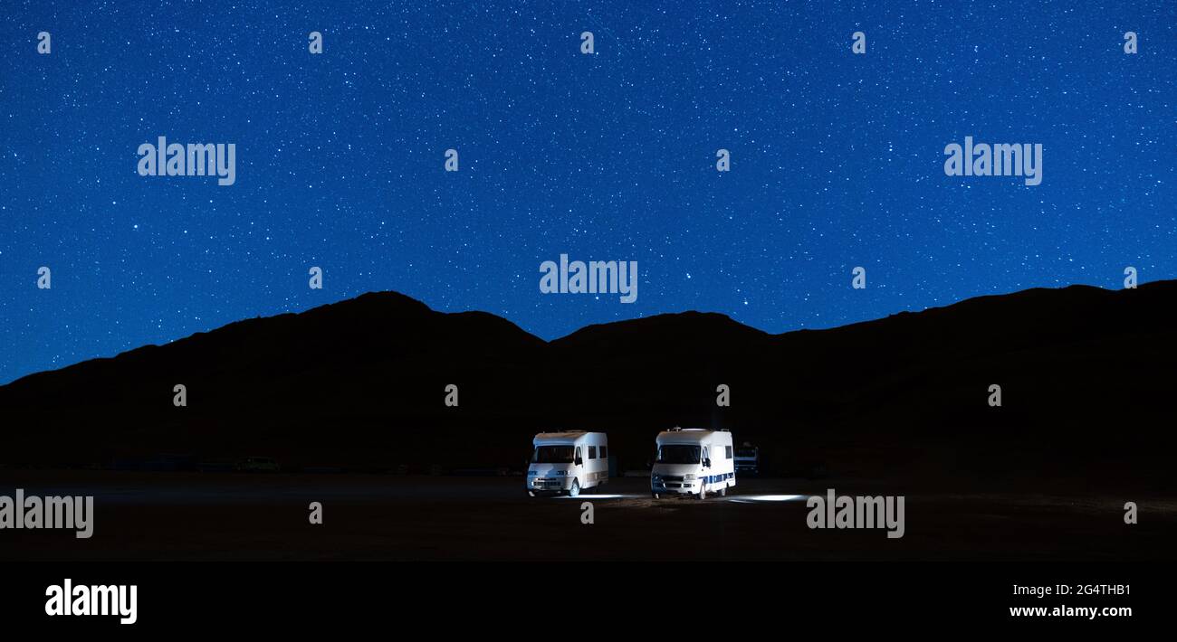 Campers parked in a caravan parking area sleeping on a starry night in ...