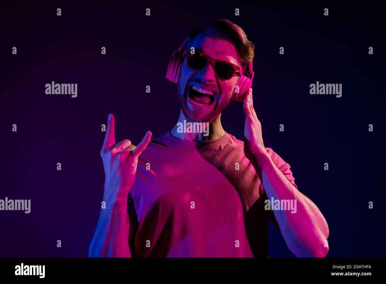 Portrait of attractive cheerful crazy guy listening bass sound showing ...
