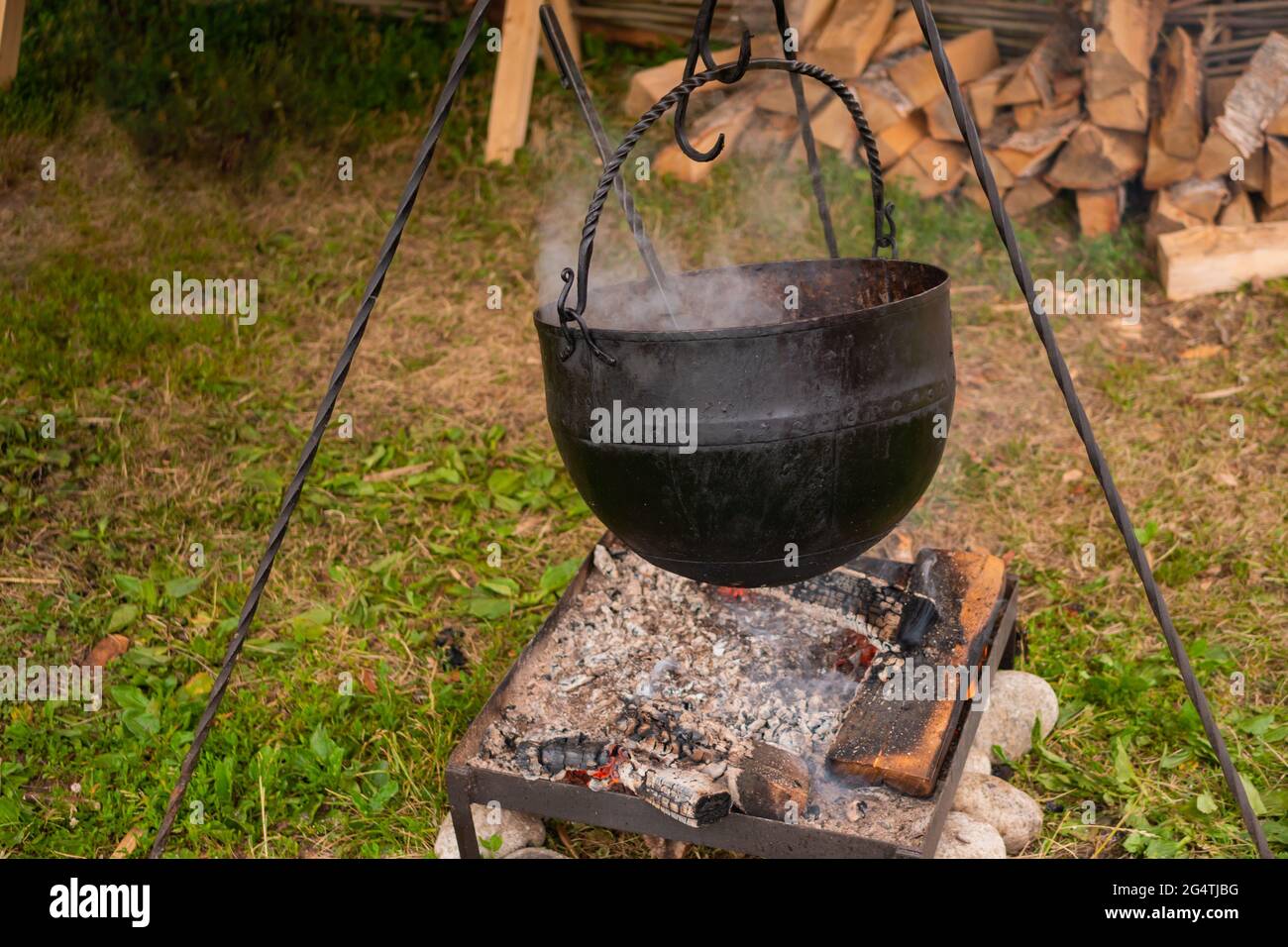 Preparing food in hanging pot over open fire - camping concept Stock ...