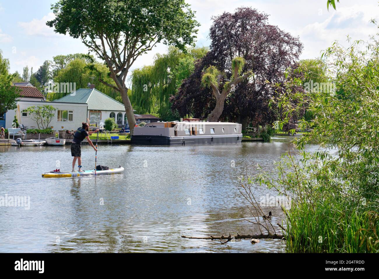 A young man paddle boarding on the River Thames by Pharaohs Island on a ...
