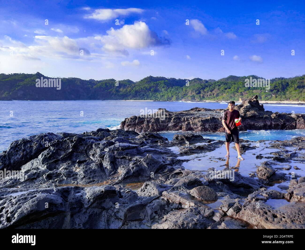 Young wet Asian man standing in water puddle on a rock plateau Stock ...