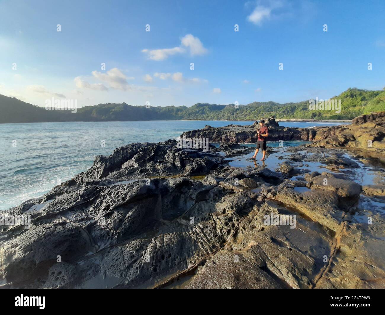 Young wet Asian man standing in water puddle on a rock plateau Stock ...