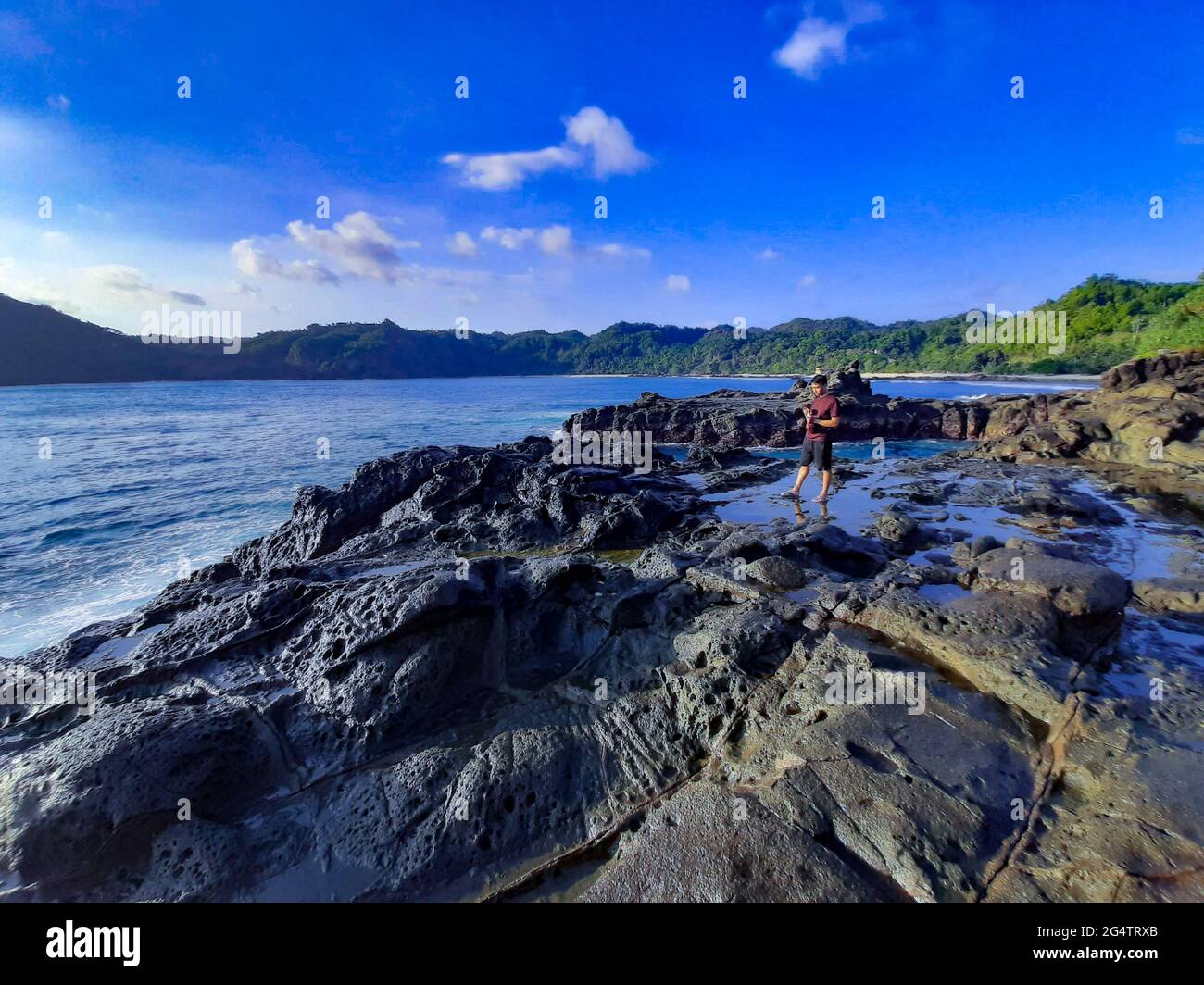 Young wet Asian man standing in water puddle on a rock plateau Stock ...