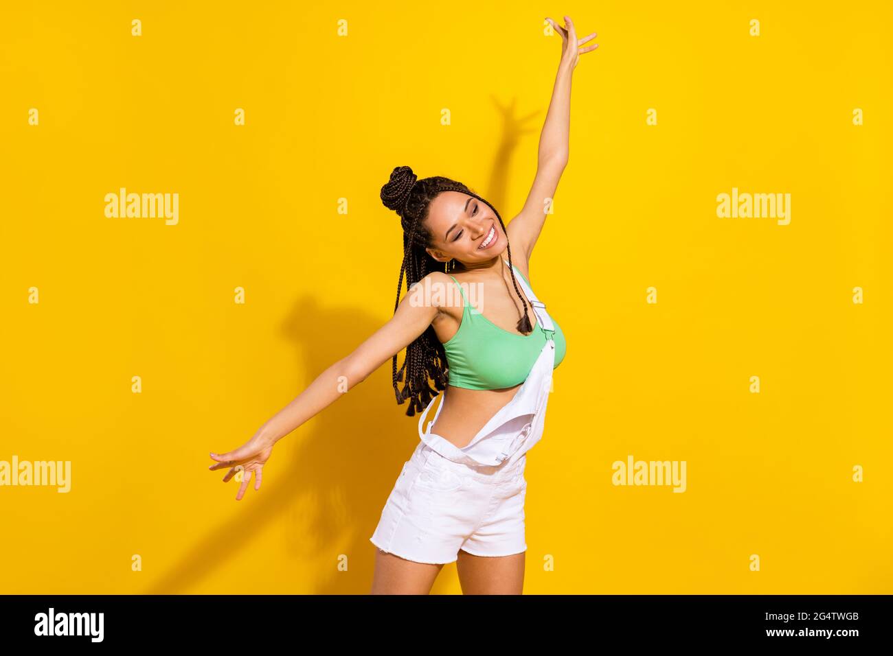 Photo of adorable shiny dark skin woman dressed white overall dancing ...