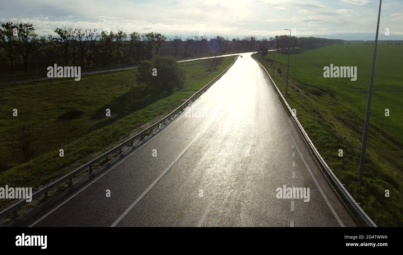 Drone above wet asphalt road for cars between sown fields Stock Photo ...
