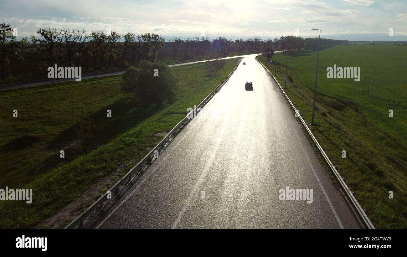Drone above wet asphalt road for cars between sown fields Stock Photo ...