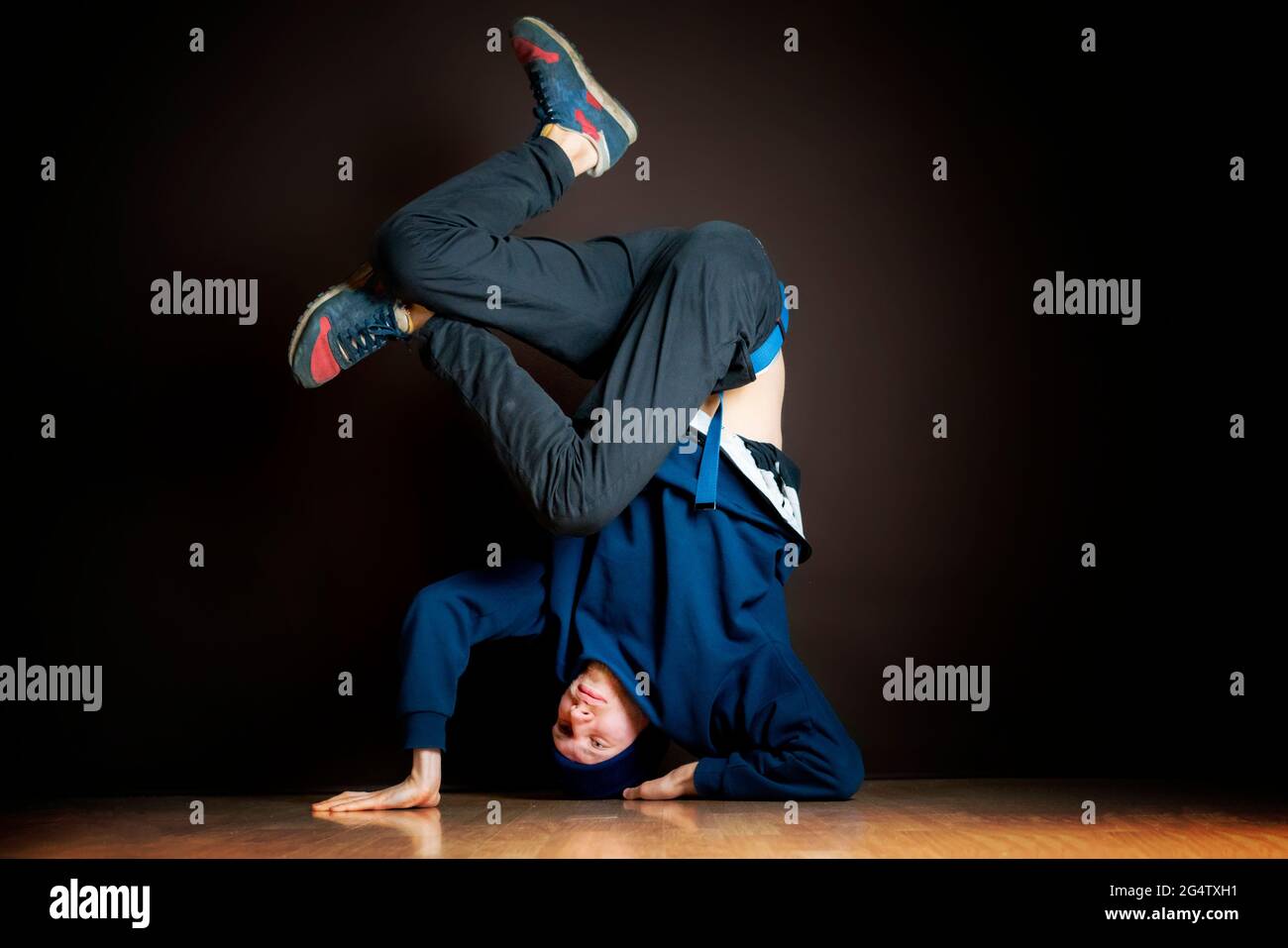 hip hop dancer perform headstand upside down in dark studio Stock Photo ...
