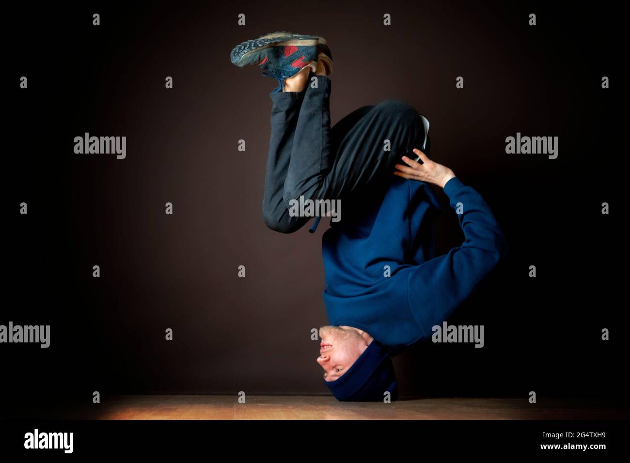 hip hop dancer perform headstand upside down in dark studio Stock Photo ...