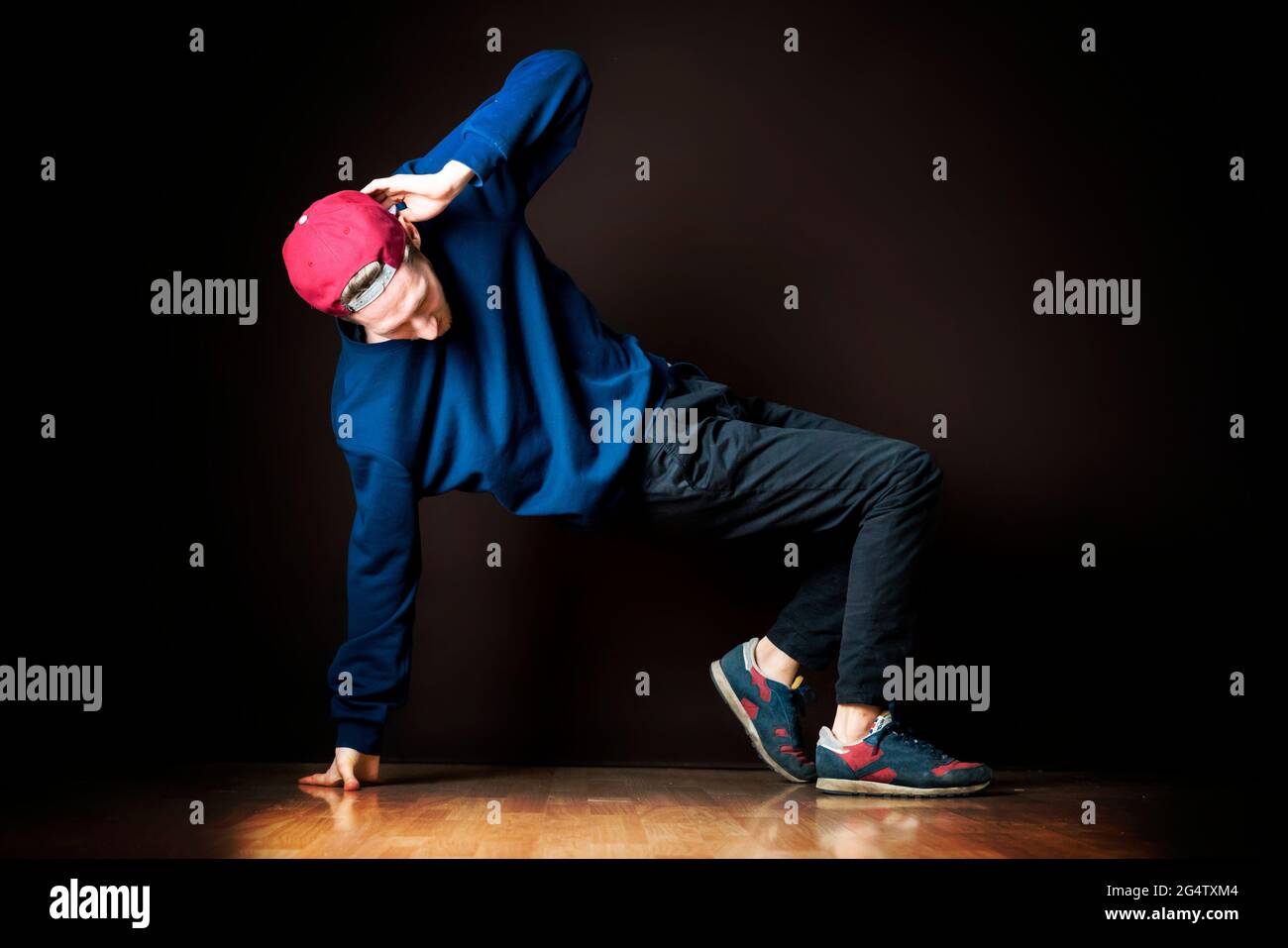 closeup photo of male break dancer performing stance against dark ...