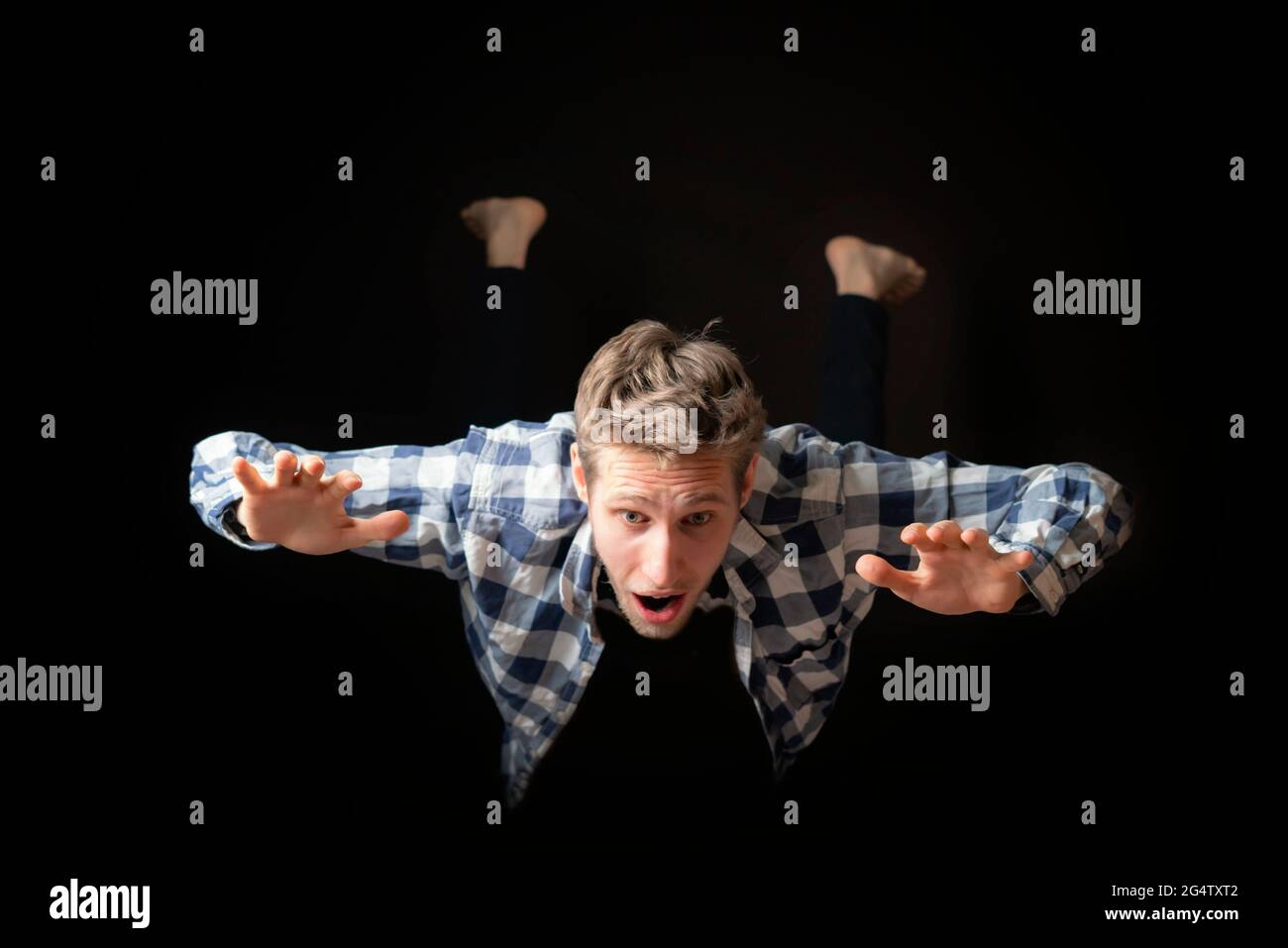 attractive scared male fall down from height on dark background Stock ...