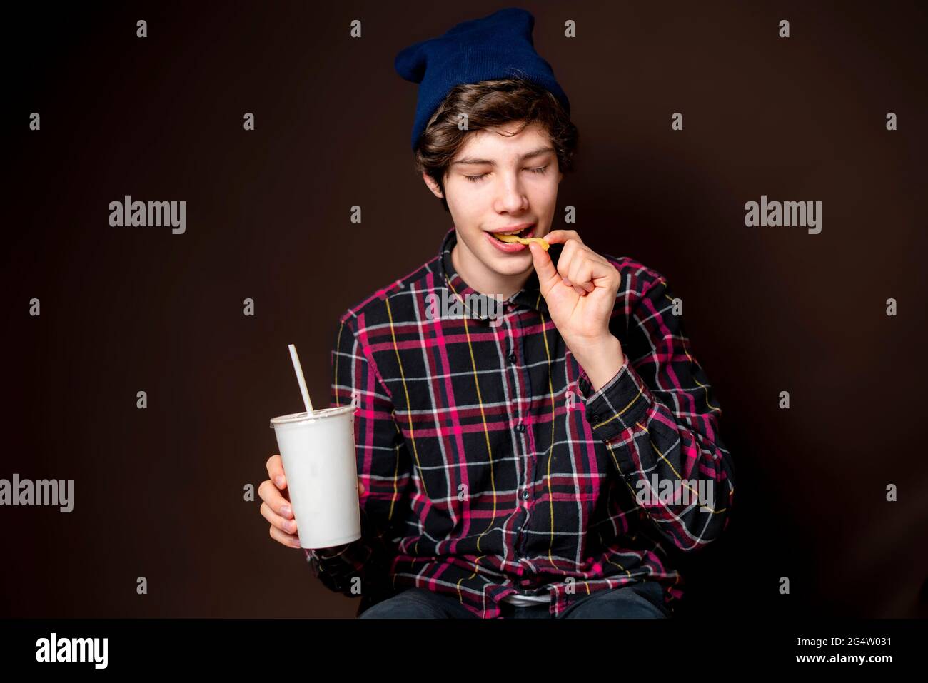 young male drink lemonade on dark background isolated Stock Photo - Alamy