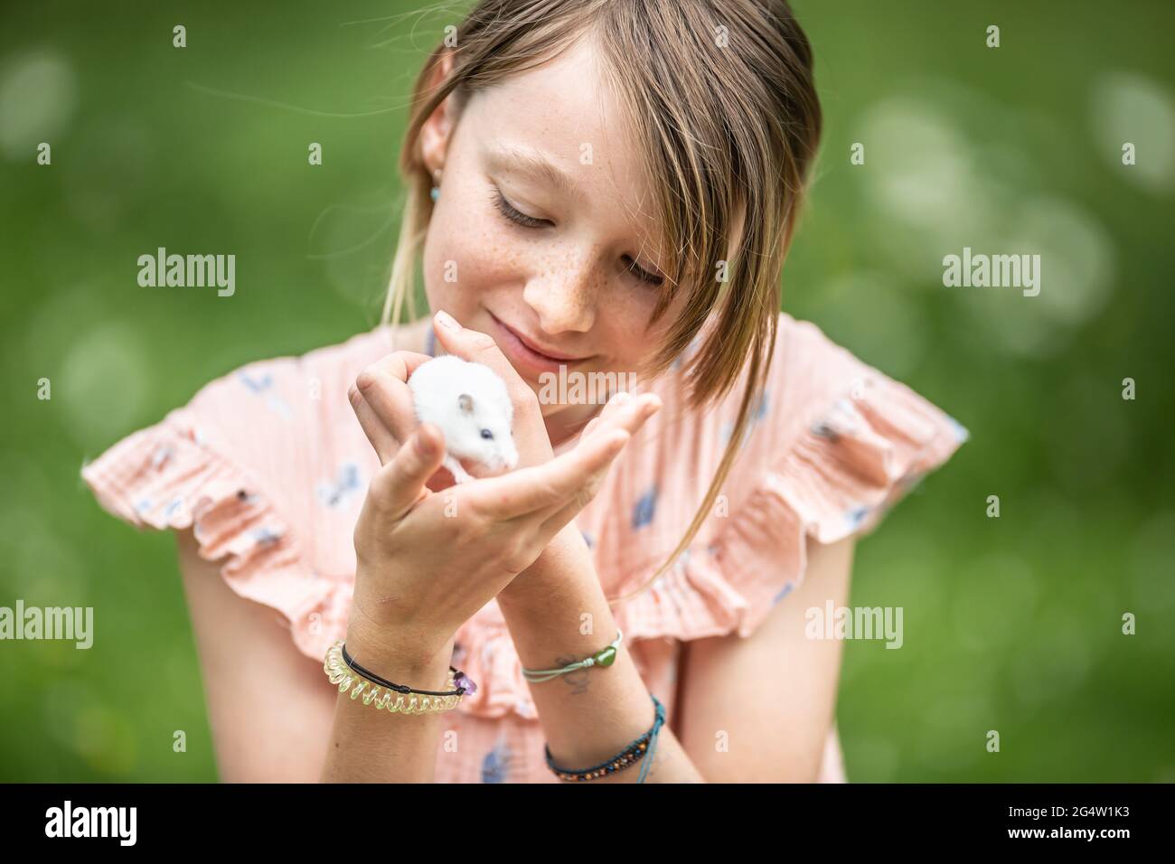 Young girl taking care of a small mouse Stock Photo - Alamy