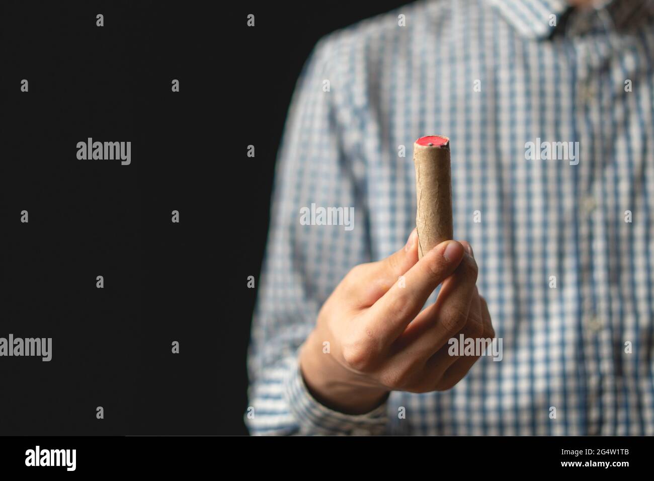 close up hand hold cracker and fire it on dark background isolated ...